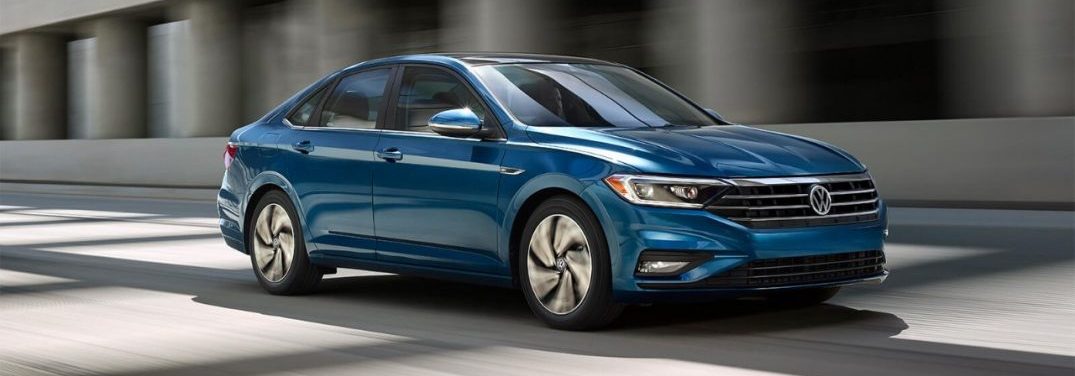 2019 Volkswagen Jetta side profile driving on a highway by some pillars