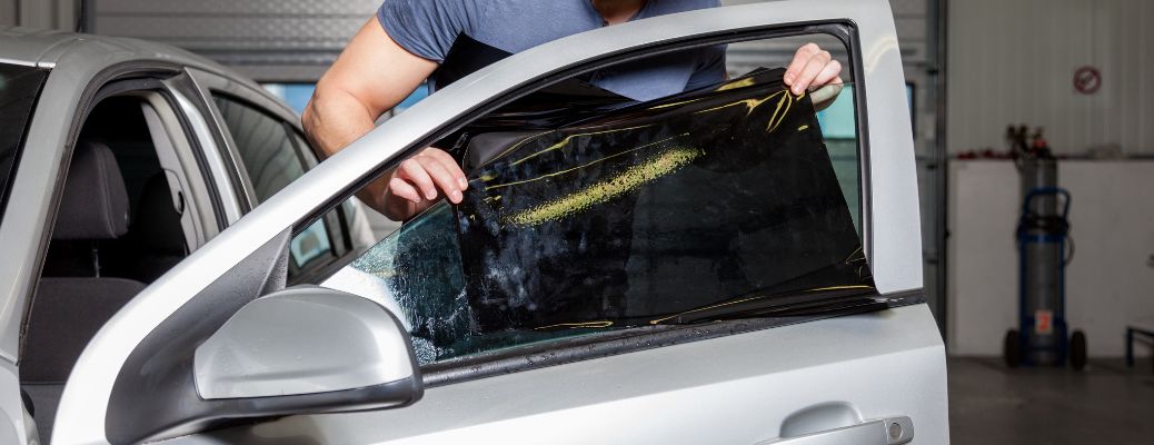 a man tinting car windows